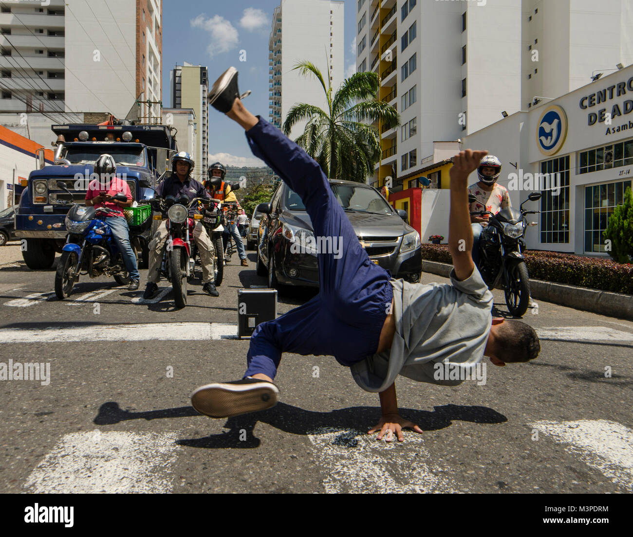 A boy from Venezuela dances on a red light in front of a line of cars ...