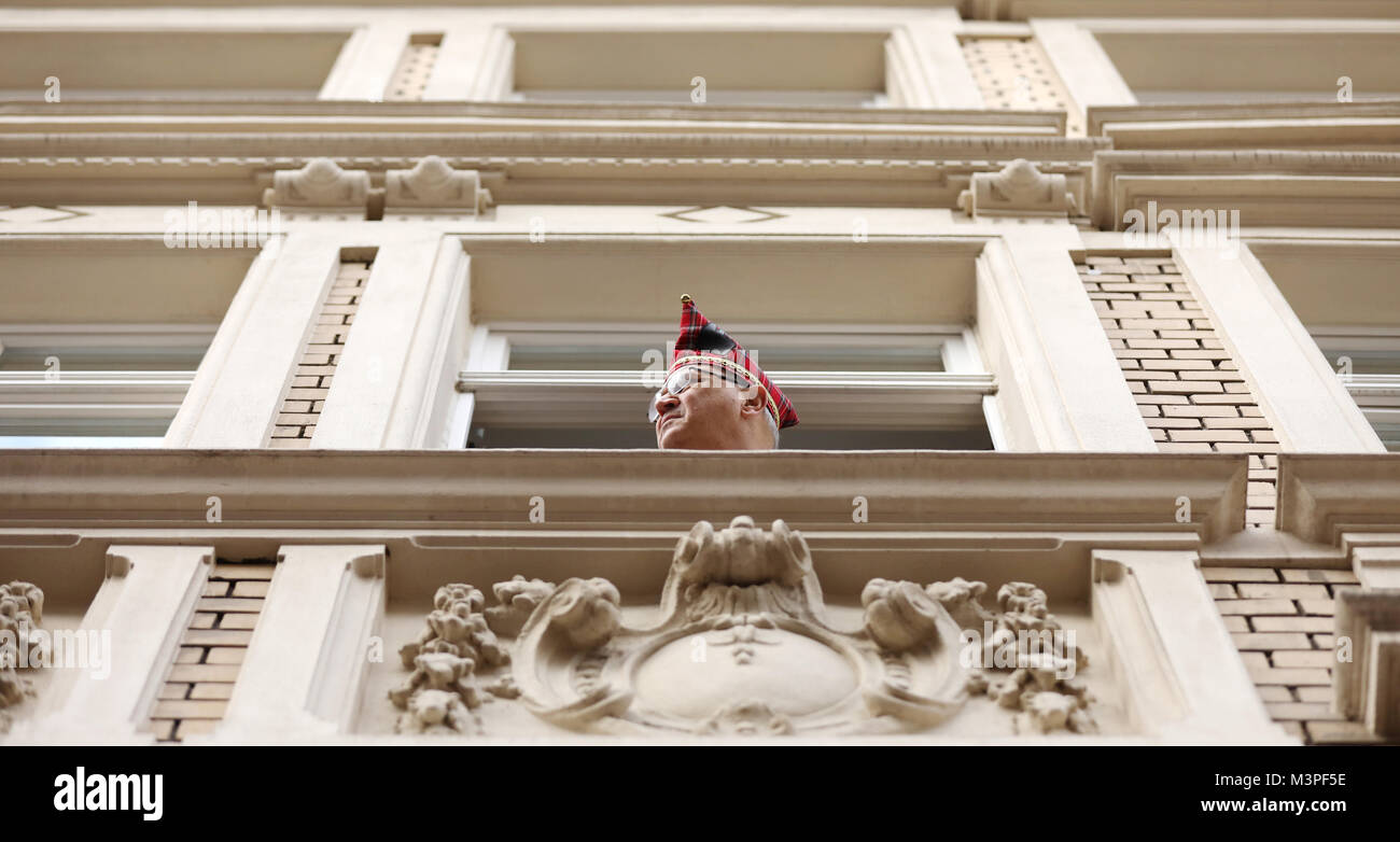 A man in a carnival hat looking out of a window at the Rosenmontag ...