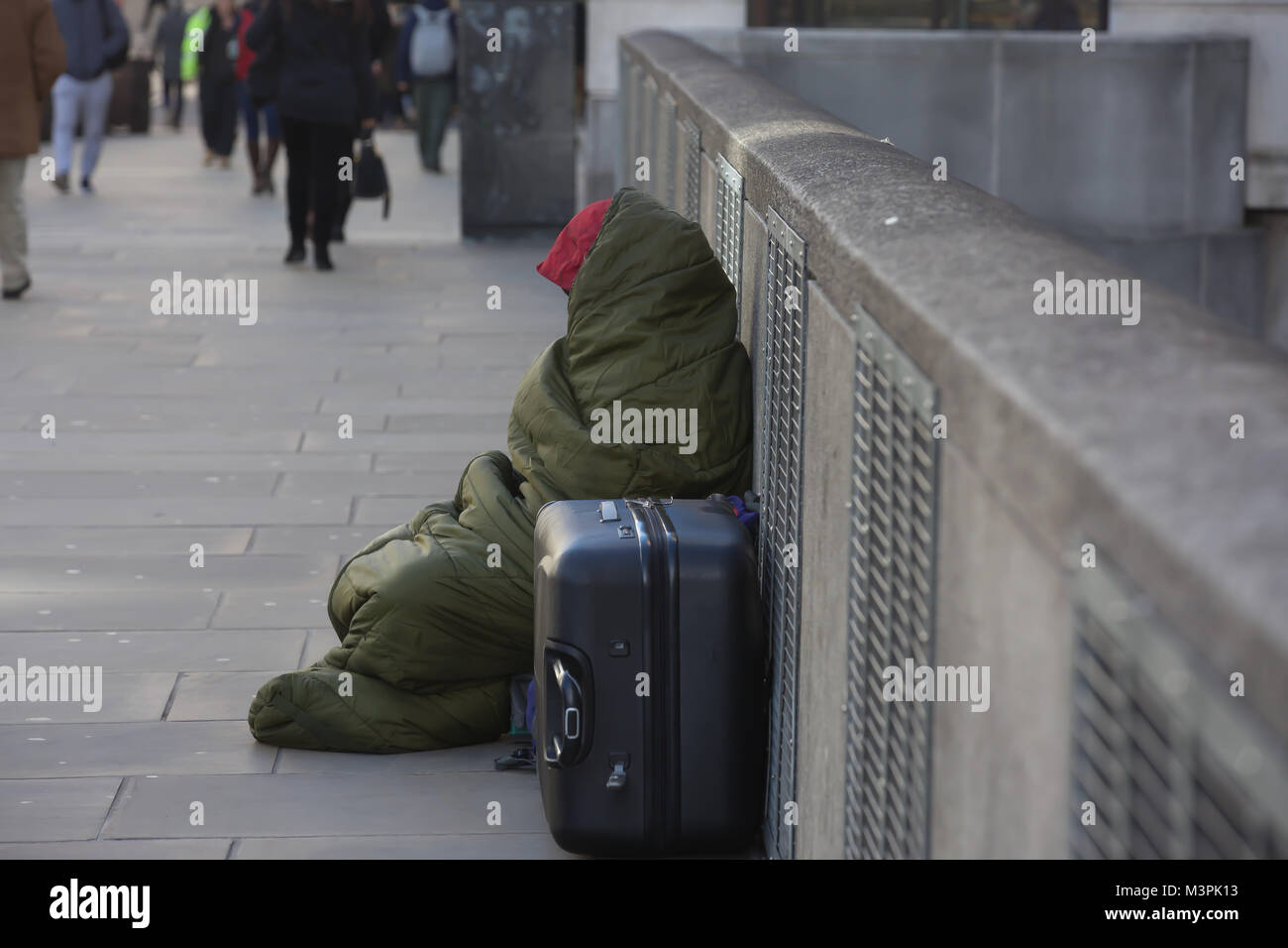 London,UK,12th February 2018,A homeless person sits wrapped up warm ...