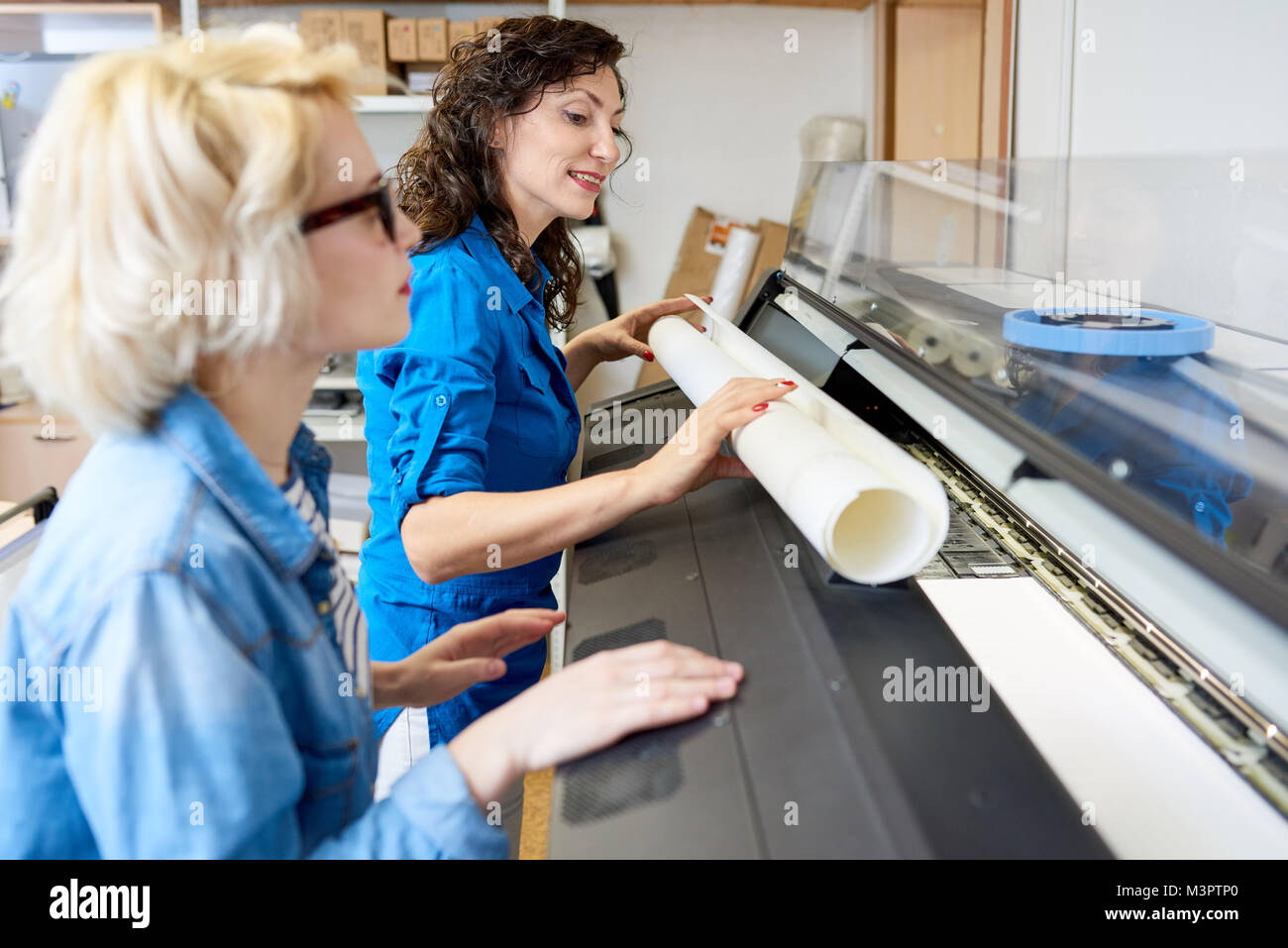 Women Changing Paper in Printing Press Stock Photo - Alamy