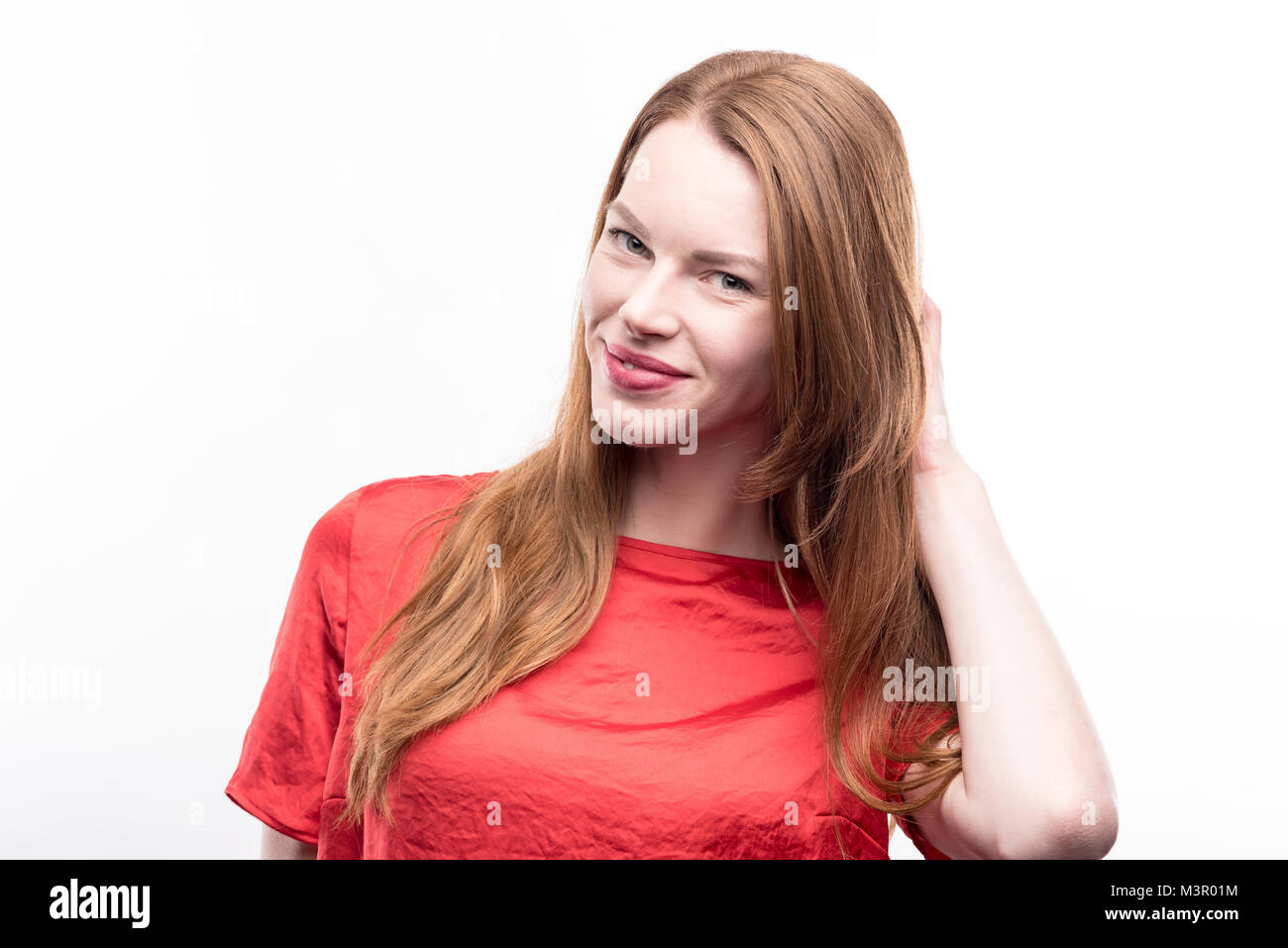Charming ginger-haired woman posing with her hand in hair Stock Photo ...