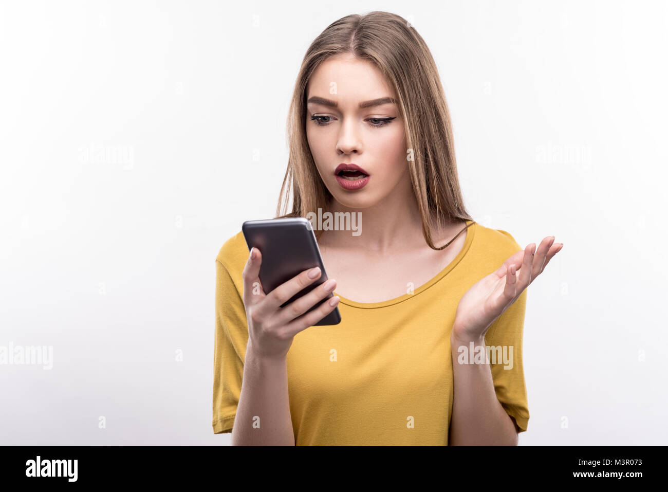 Young woman being indignant about content of message Stock Photo - Alamy