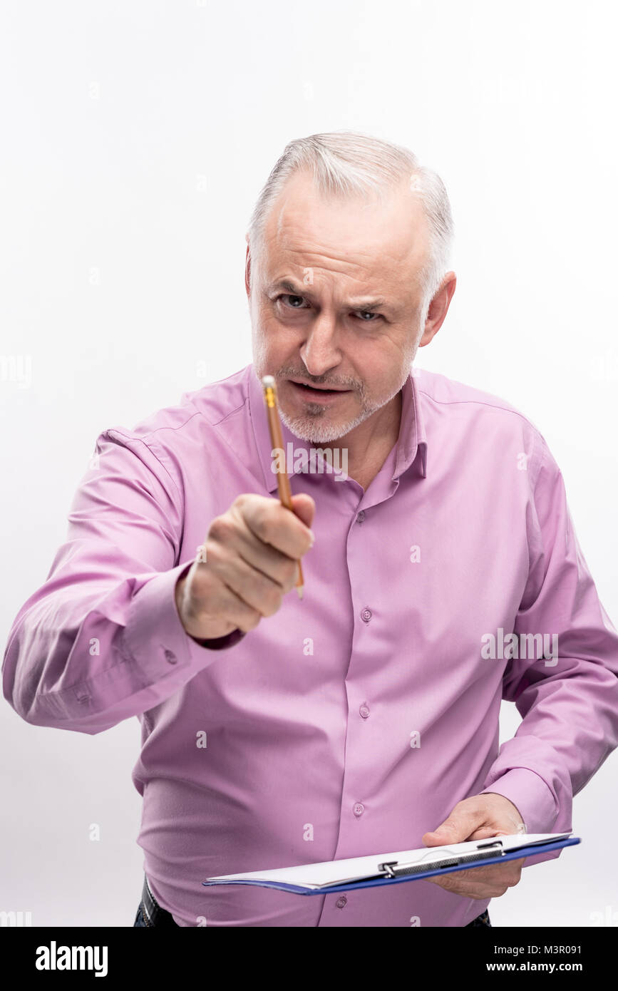 Angry grey-haired man pointing with pencil threateningly Stock Photo ...