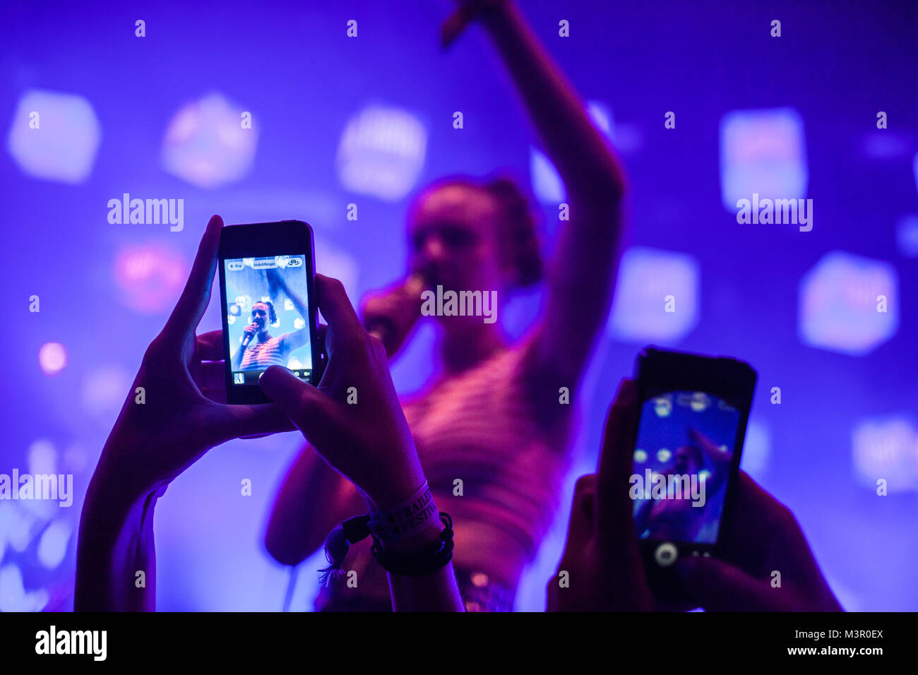Concert guests do photos with their smart phones at a live concert ...