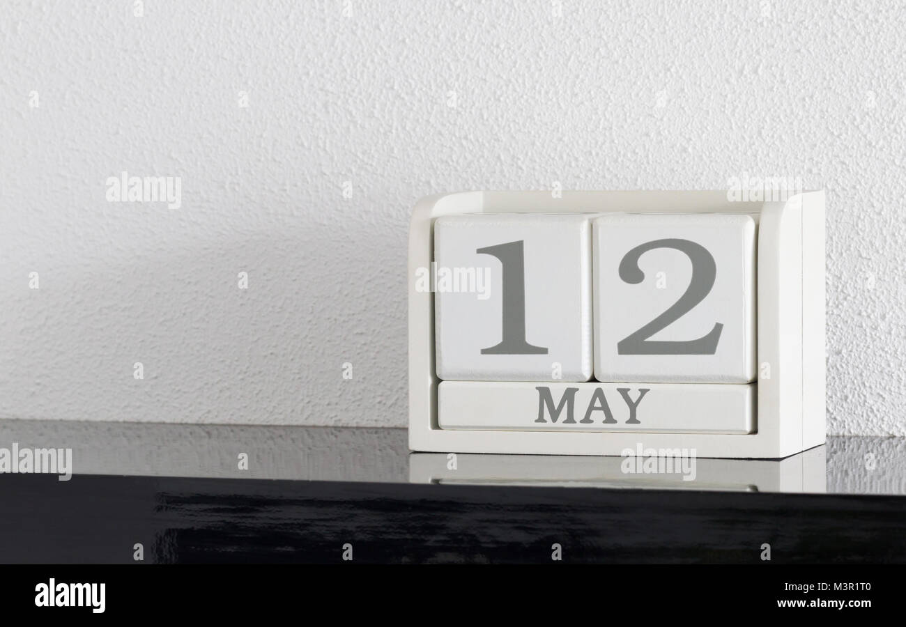 White block calendar present date 12 and month May on white wall ...