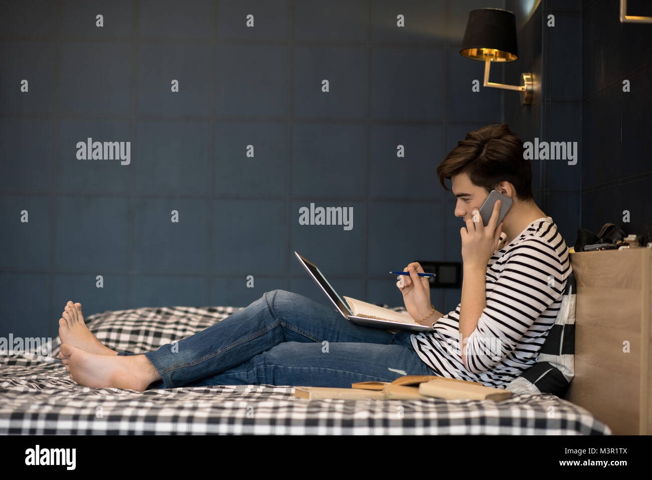 Teenage Boy Doing Homework in Bed Stock Photo - Alamy