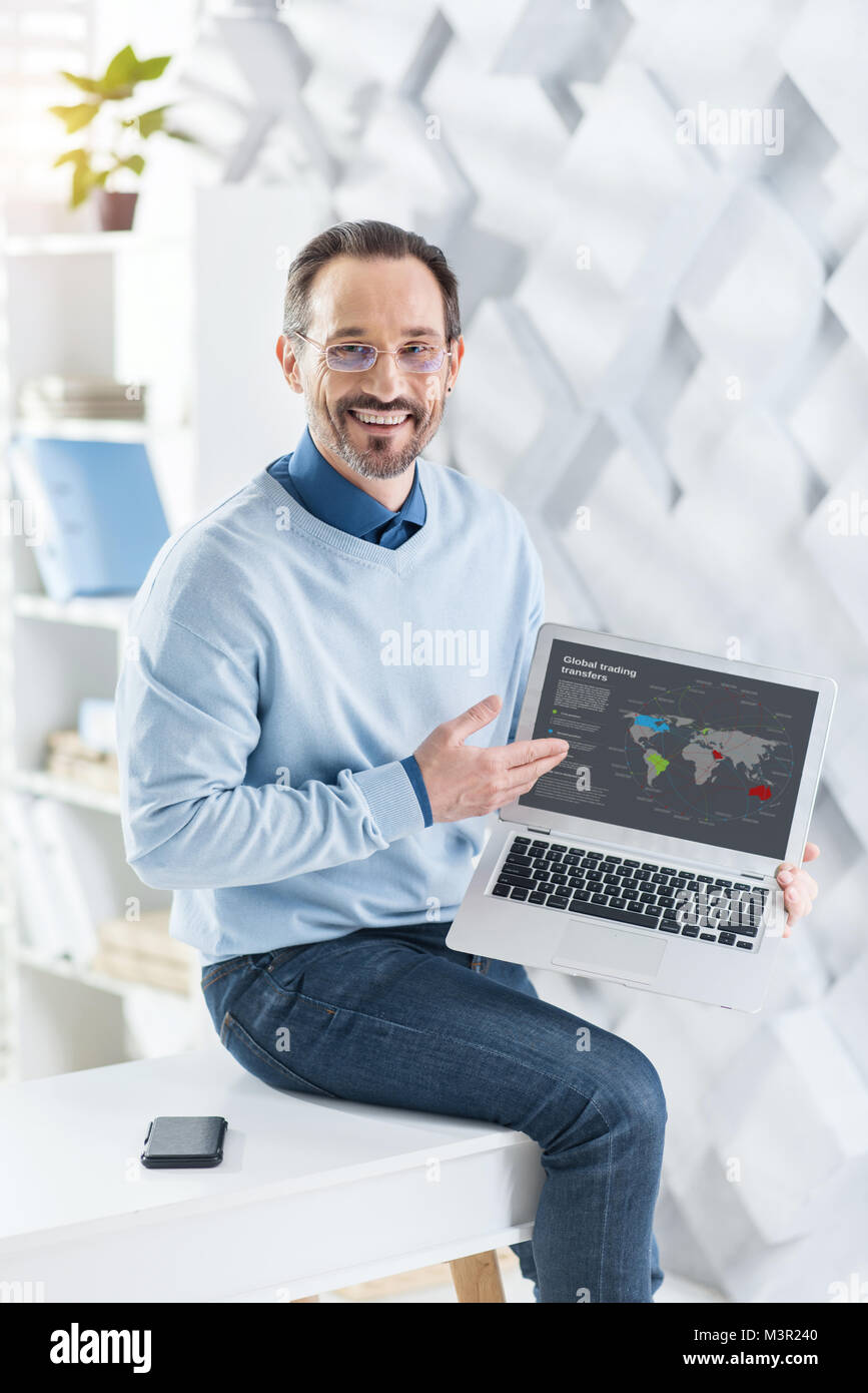 Happy businessman showing information on his laptop Stock Photo - Alamy