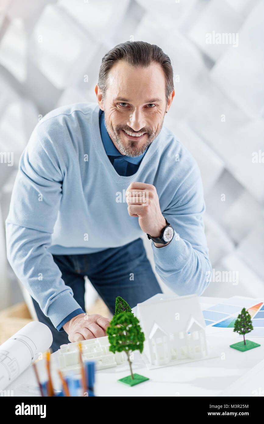 Happy architect constructing the model of a house Stock Photo - Alamy