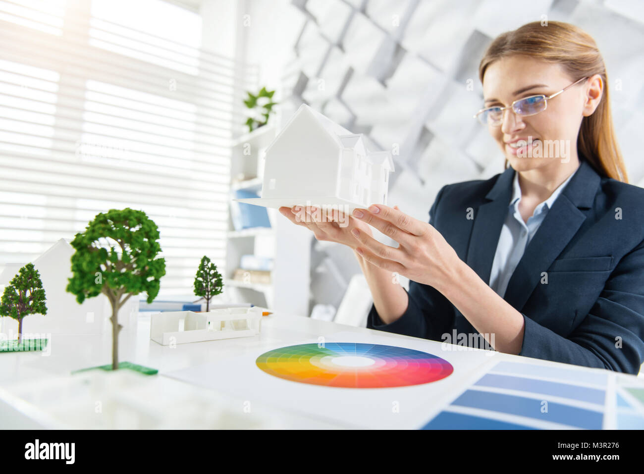Content engineer holding a model of the house Stock Photo - Alamy