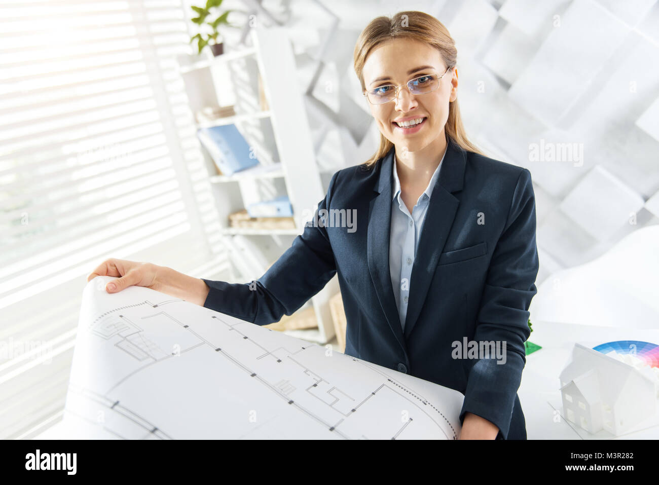 Exuberant smiling engineer holding a drawing Stock Photo - Alamy