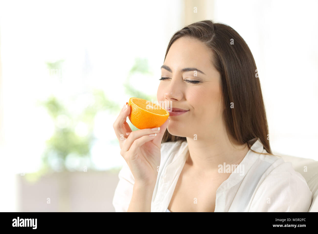 Woman smelling orange fruit hi-res stock photography and images - Alamy