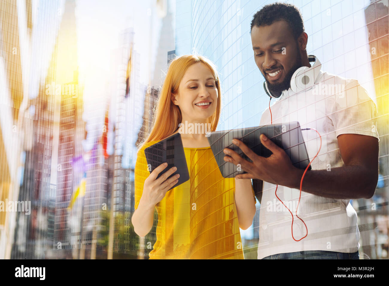Positive friendly students smiling and looking at the screen of a ...