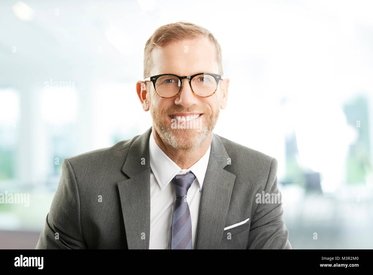 Senior male investment advisor with toothy smile wearing suit while ...