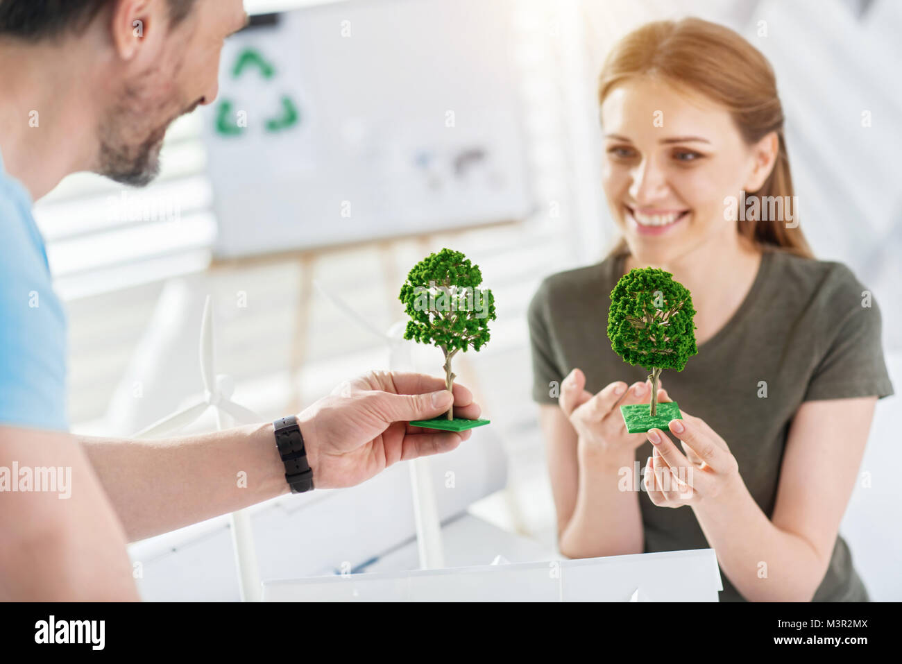 Smiling landscape artists holding trees miniatures Stock Photo - Alamy