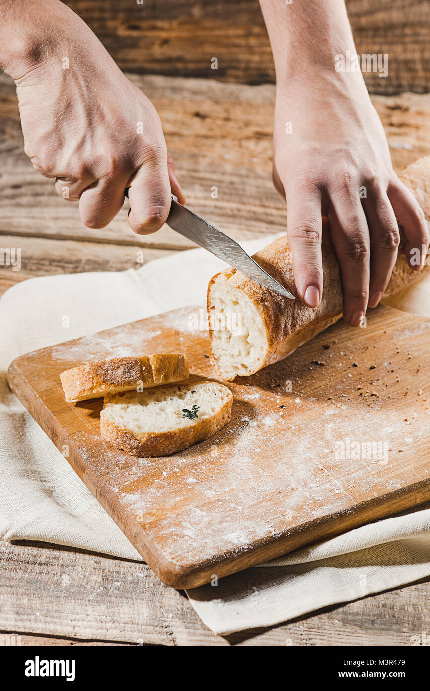 Whole grain bread put on kitchen wood plate with a chef holding gold ...