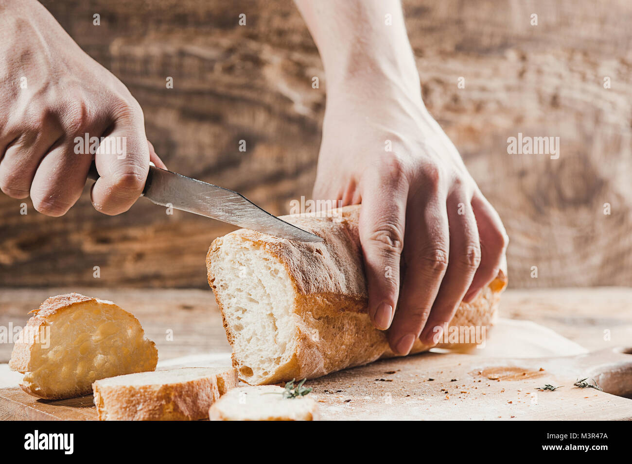 Whole grain bread put on kitchen wood plate with a chef holding gold ...