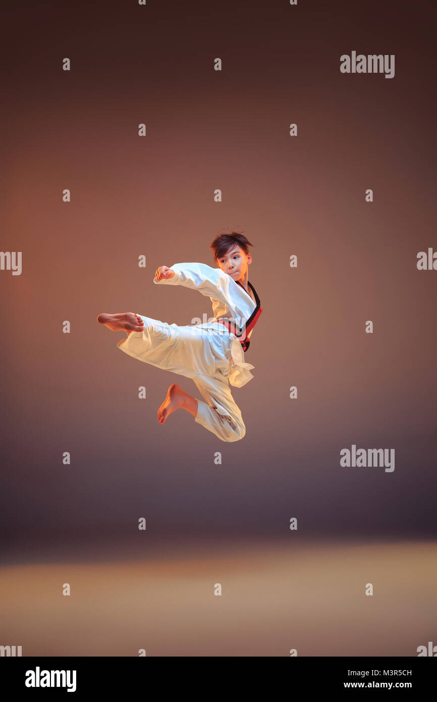 Young boy training karate on blue background Stock Photo - Alamy
