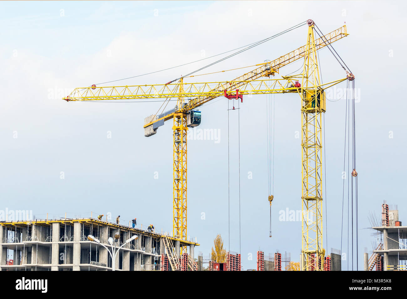 Several cranes and buildings against blue sky. Construction site of ...