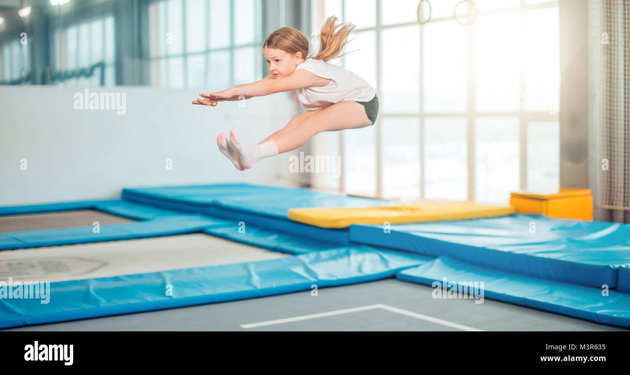 Girl jumping high in striped tights on trampoline Stock Photo - Alamy