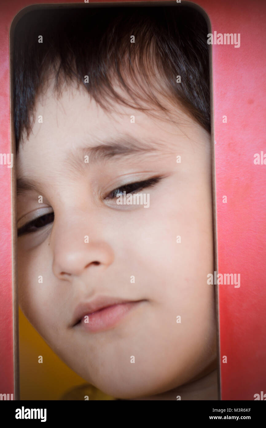 kid joking, Brunette boy putting funny faces in an outdoor park Stock ...