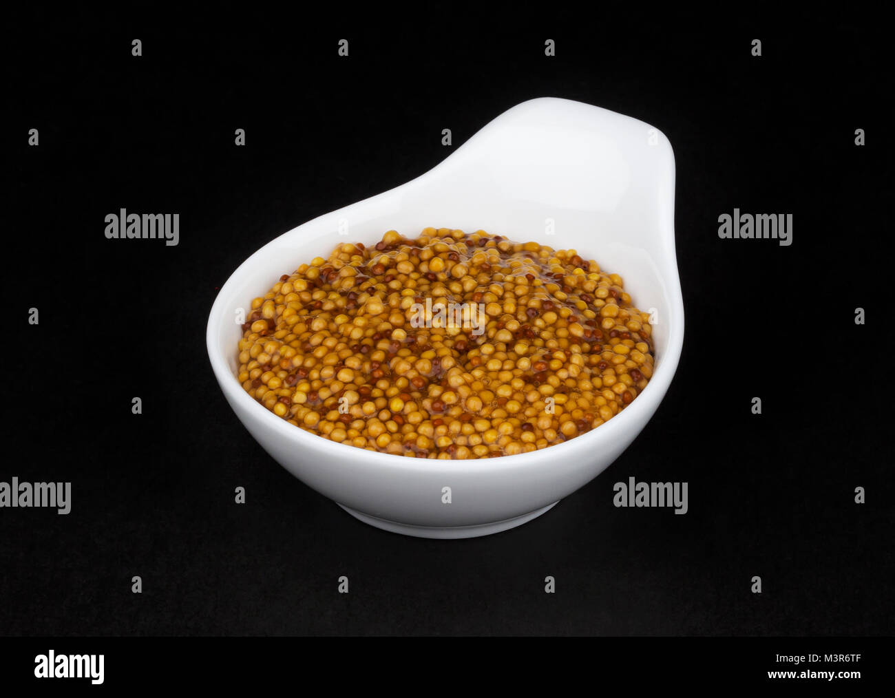 French mustard in white bowl isolated on black background Stock Photo ...