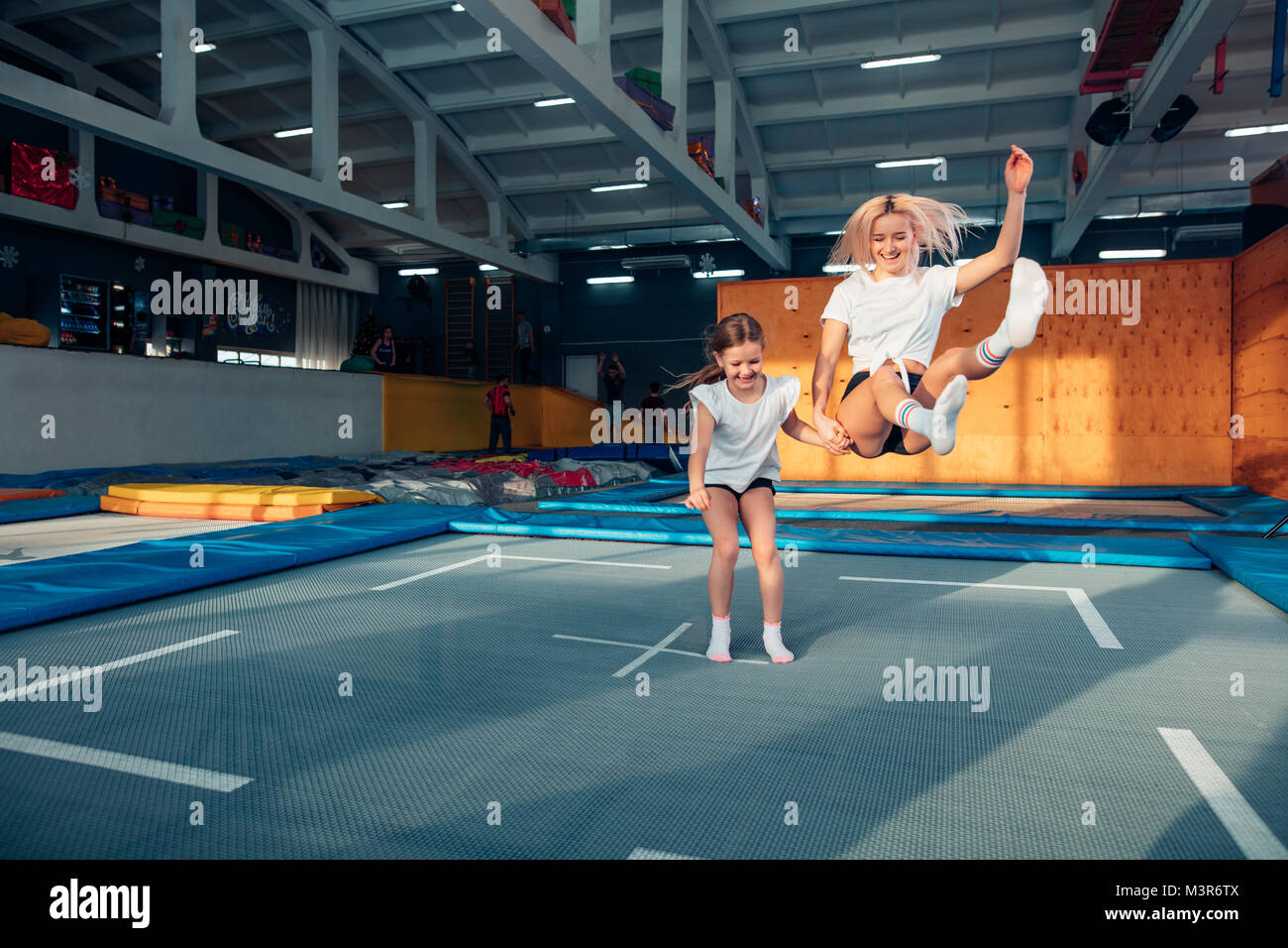 mother and daughter jumping on trampoline and doing split Stock Photo ...