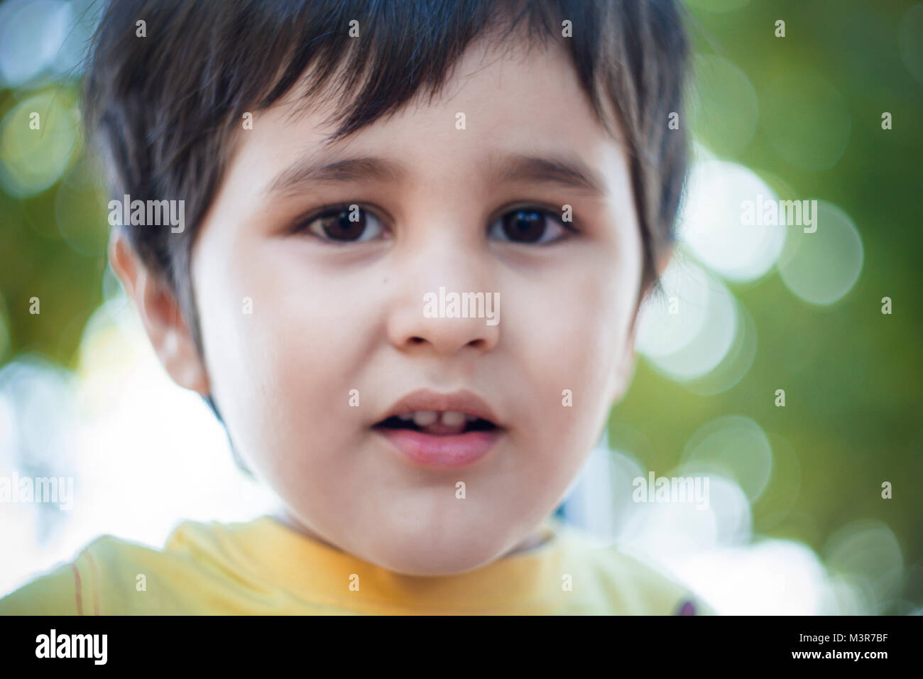 kid joking, Brunette boy putting funny faces in an outdoor park Stock ...