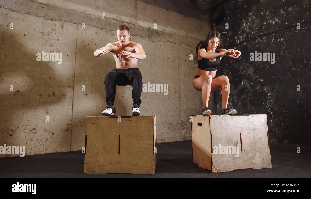 man and woman jumping on fit box Stock Photo - Alamy