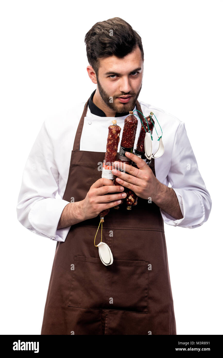 portrait of a young man in a chef's apron. Cook sniffing salami on ... portrait of a young man in a chef's apron. Cook sniffing salami on ...
