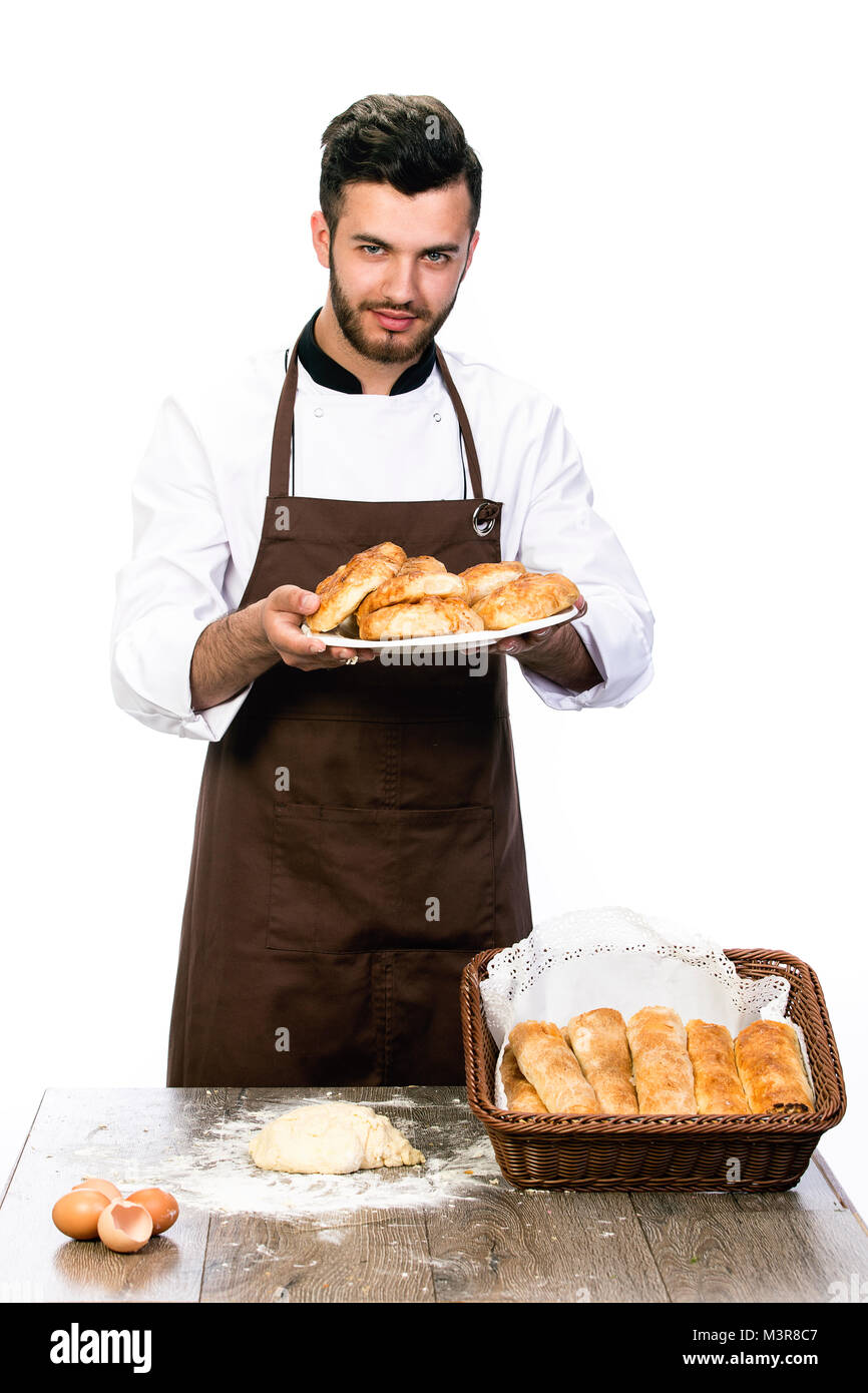 Handsome man in apron with fresh bakery isolated on white background ...