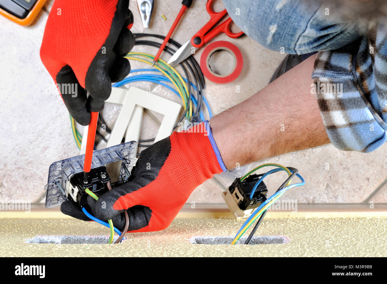 Electrician technician at work blocks the cable between the clamps of a ...