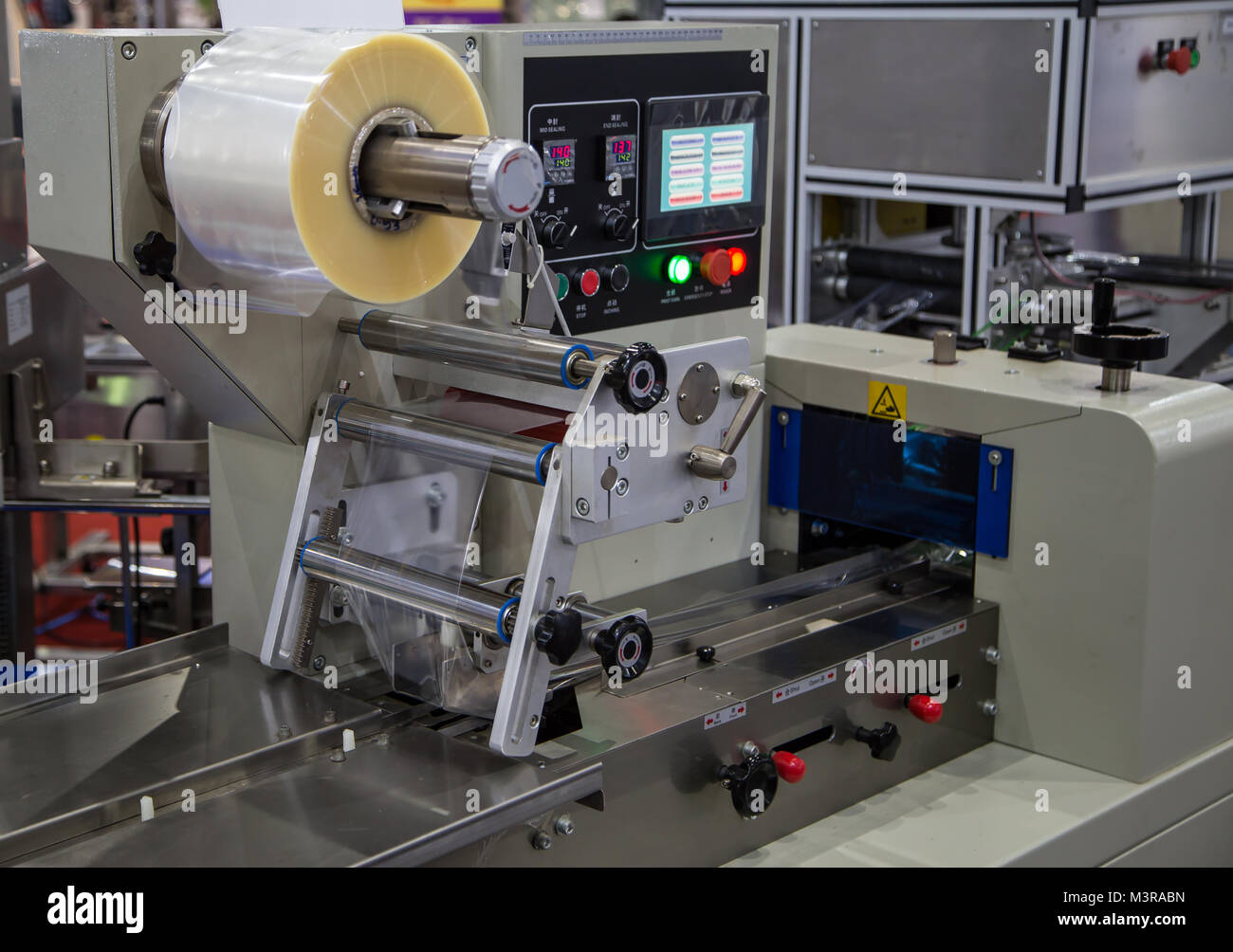 Linear tray food heat sealing and packing machine Stock Photo - Alamy