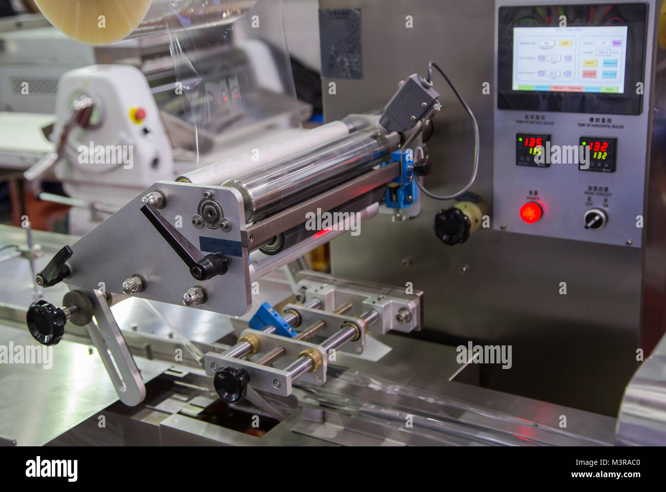 Linear tray food heat sealing and packing machine Stock Photo - Alamy