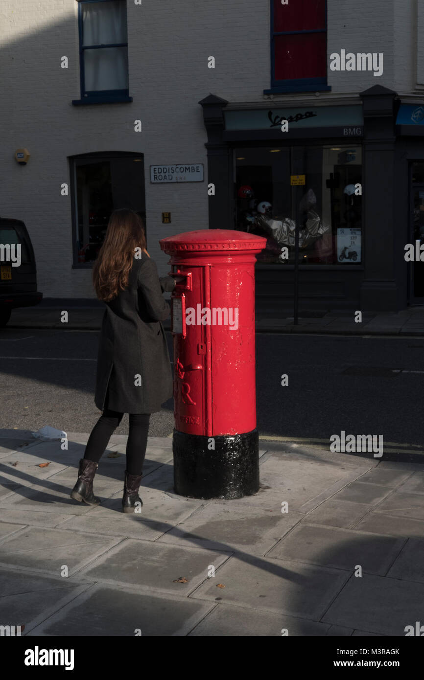 Young woman posting a letter into a Red Royal Mail Box,Parsons Green ...