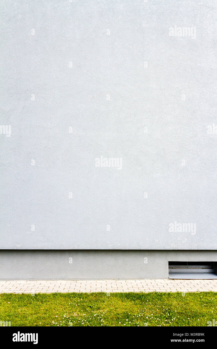 Modern light blue plaster wall with green grass Stock Photo - Alamy