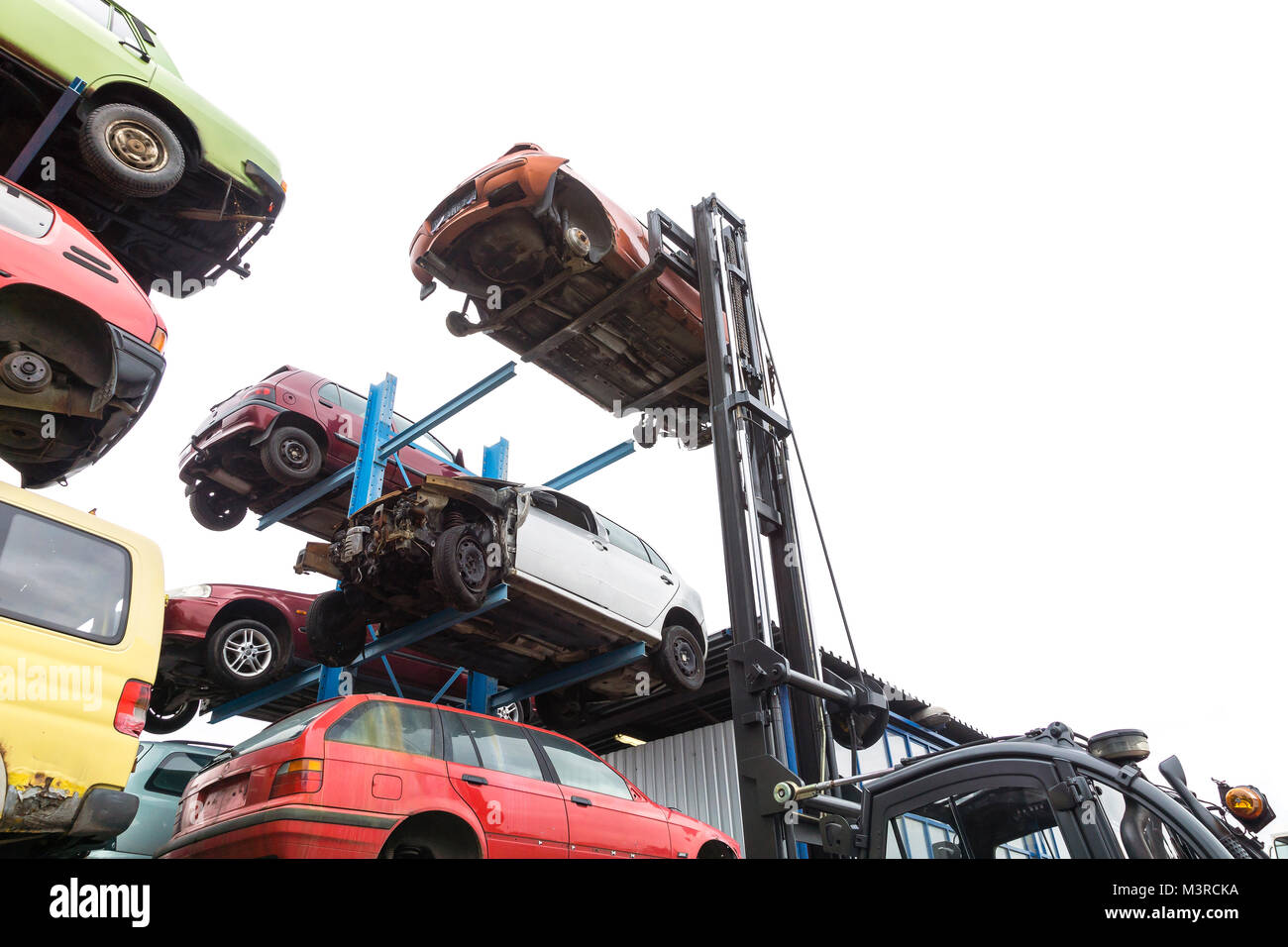 forklift hoisting car wrecks at the junkyard Stock Photo - Alamy