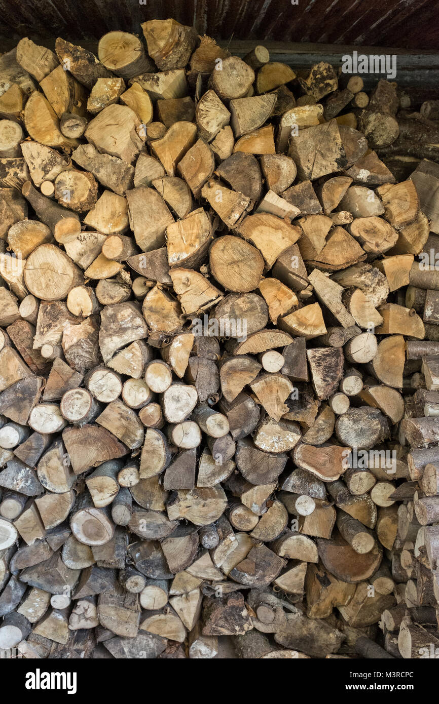 Firewood logs drying in a log store Stock Photo - Alamy
