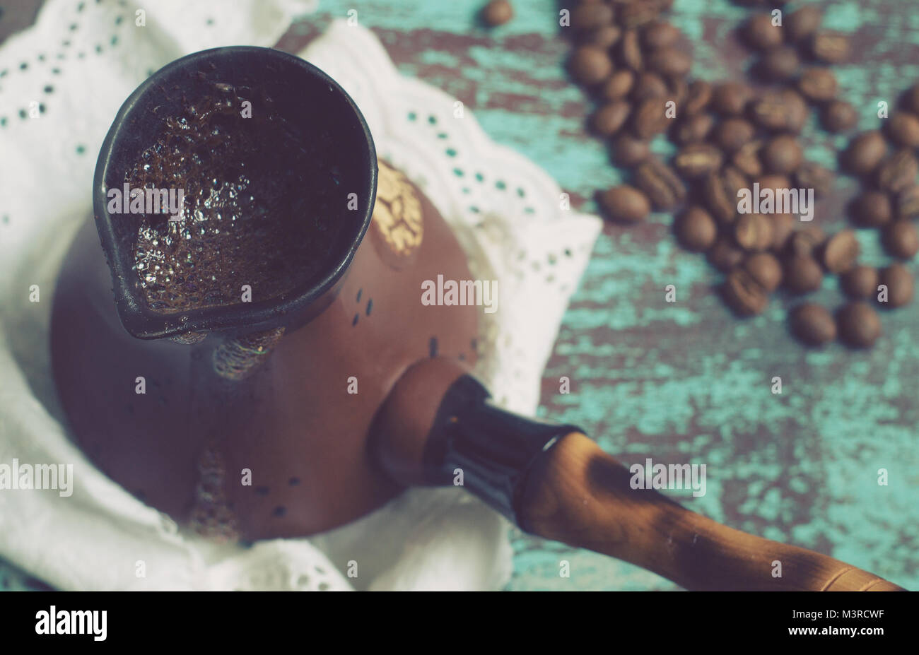 A cezve is a pot to make Turkish coffee and coffee beans on blue ...