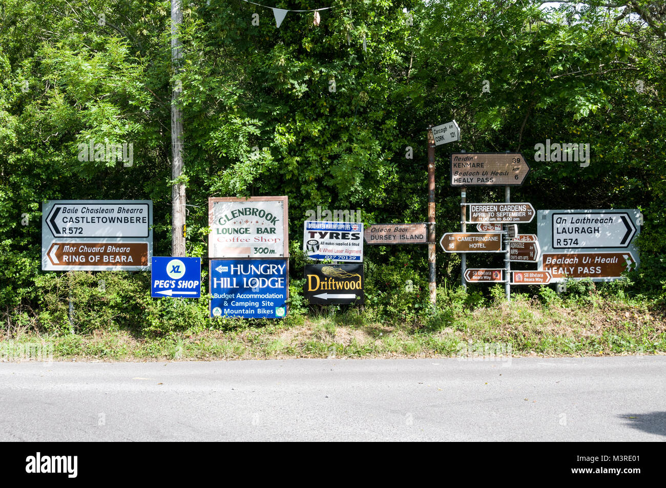 A clutter of road direction signs beside a busy road junction in Beara ...