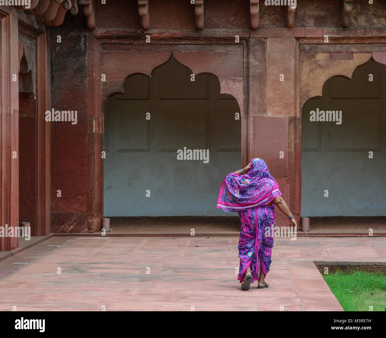 A woman in traditional dress (saree) walking at Agra Fort in Agra ...