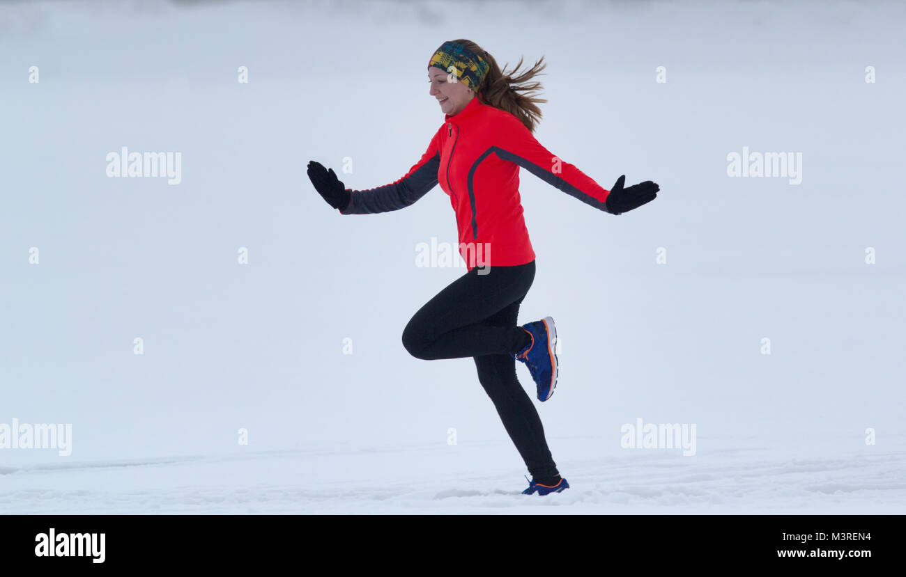 Young female athlete running in winter through the snow Stock Photo - Alamy