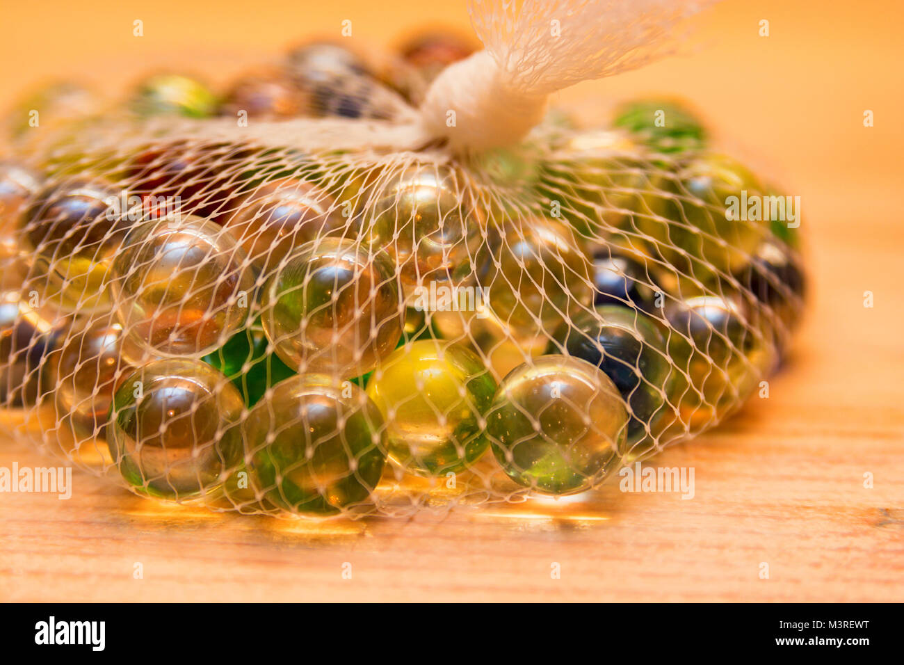 Colorful glass marbles in net Stock Photo - Alamy