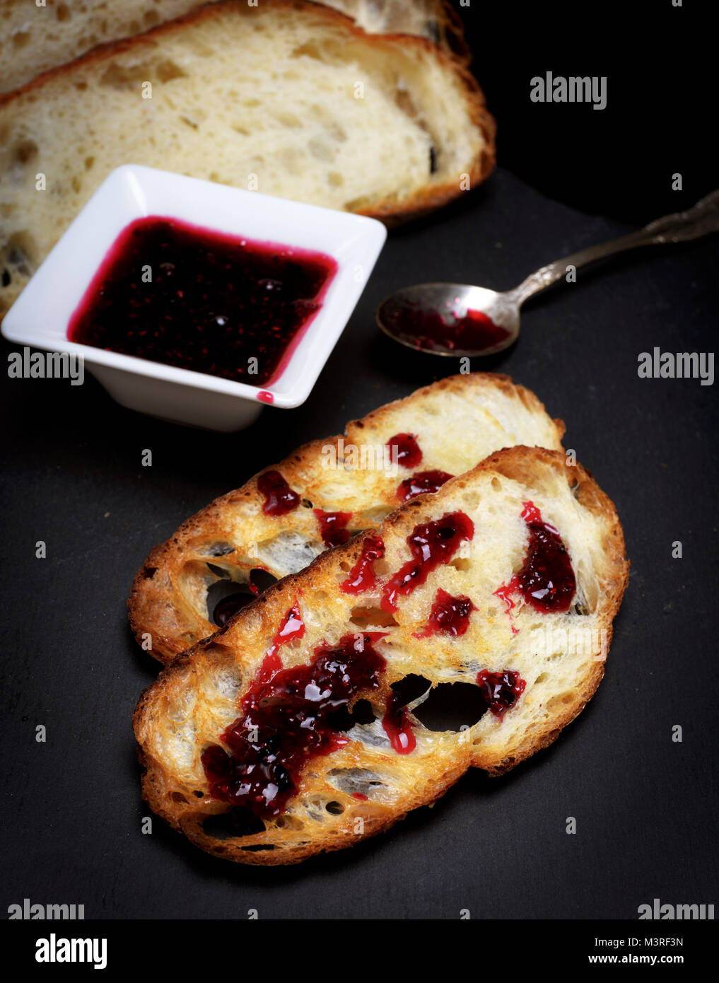 toasts of white bread and raspberry jam on a black background Stock ...