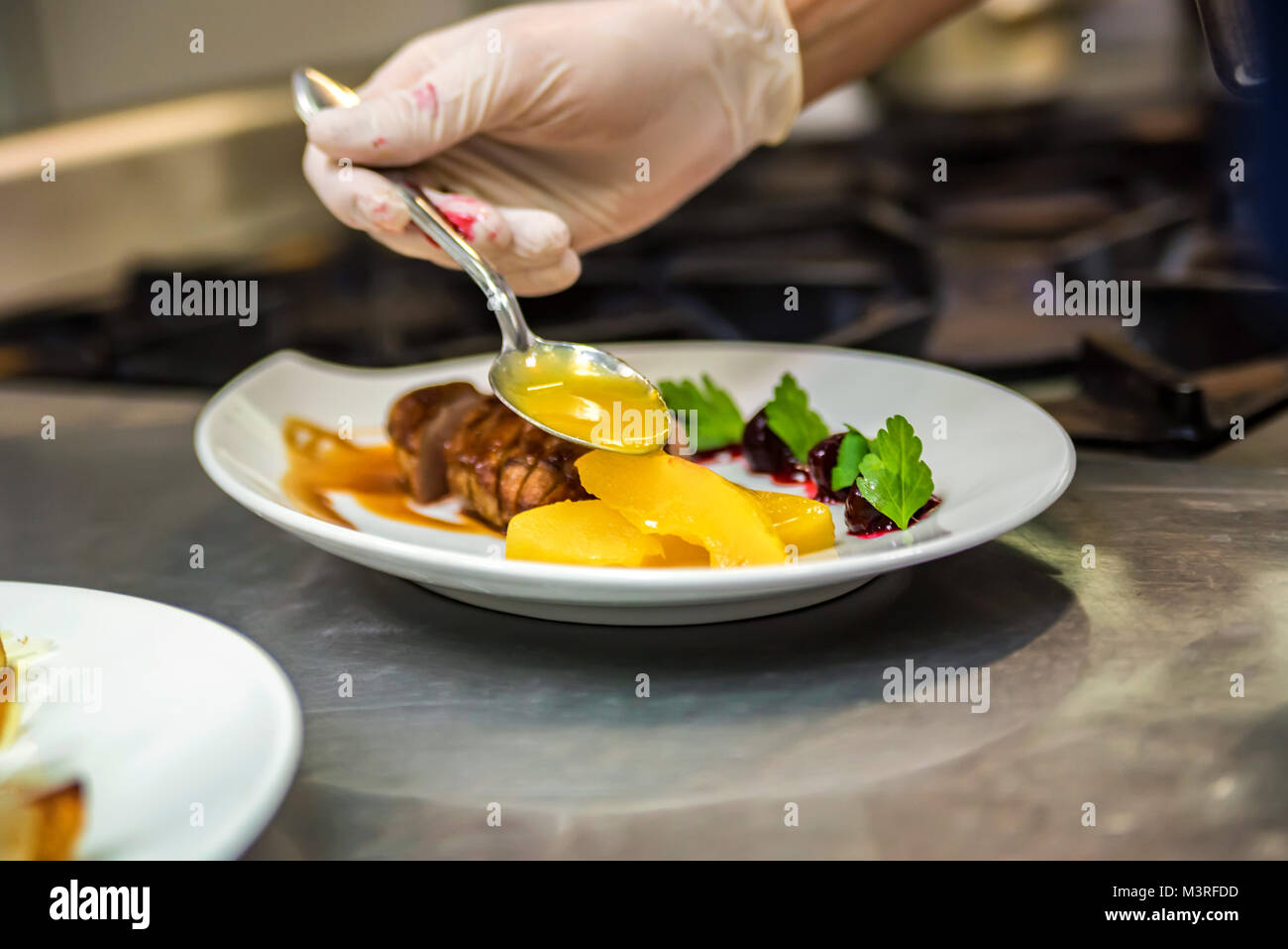 Hand adds sauce to steak Stock Photo - Alamy