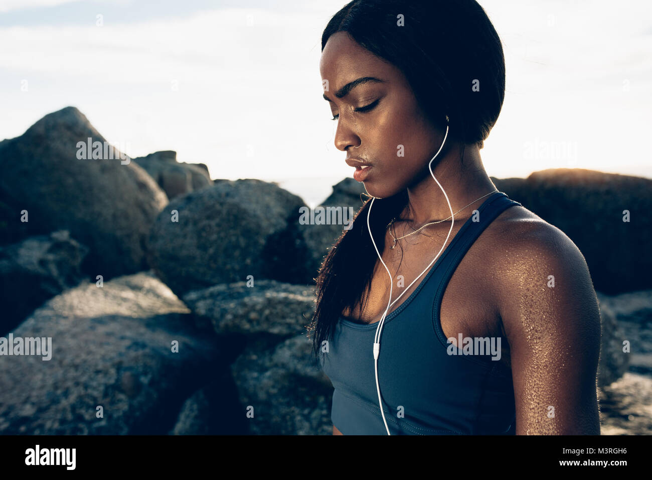Healthy young woman with sweat standing outdoors after her workout ...