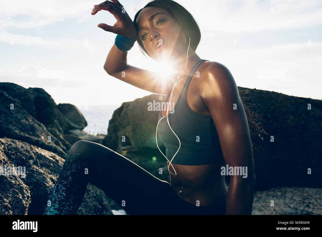 Fitness female looking tired after intense physical training with sun ...