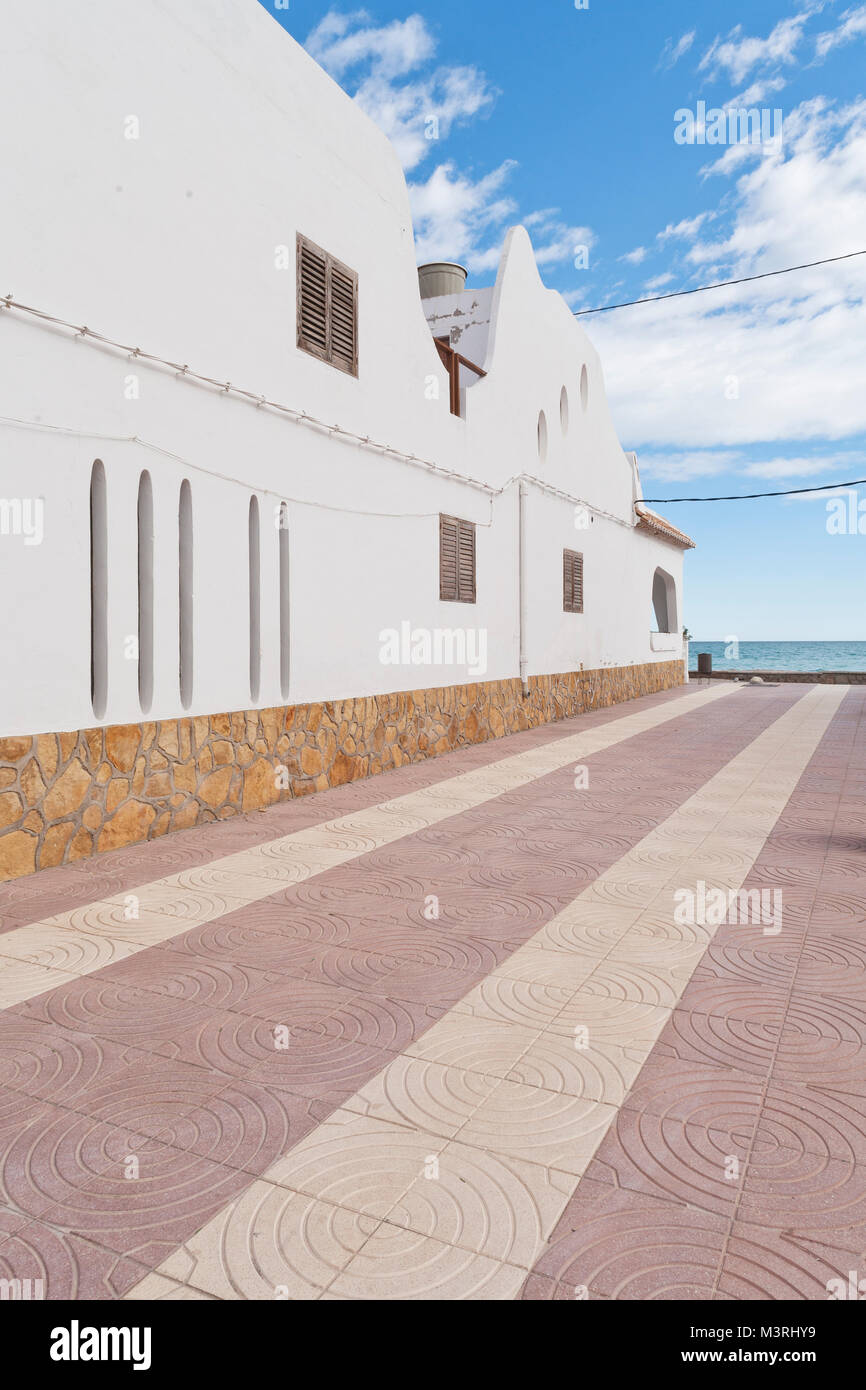 whitewashed building and path leading to the beach of Moncofa, Spain ...
