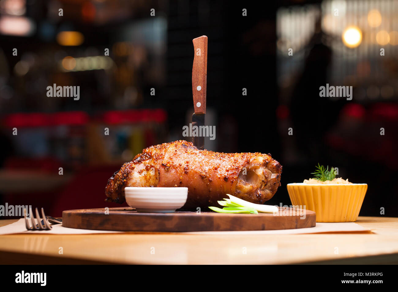 Restaurant dish - a large baked pork knuckle on a wooden tray Stock ...