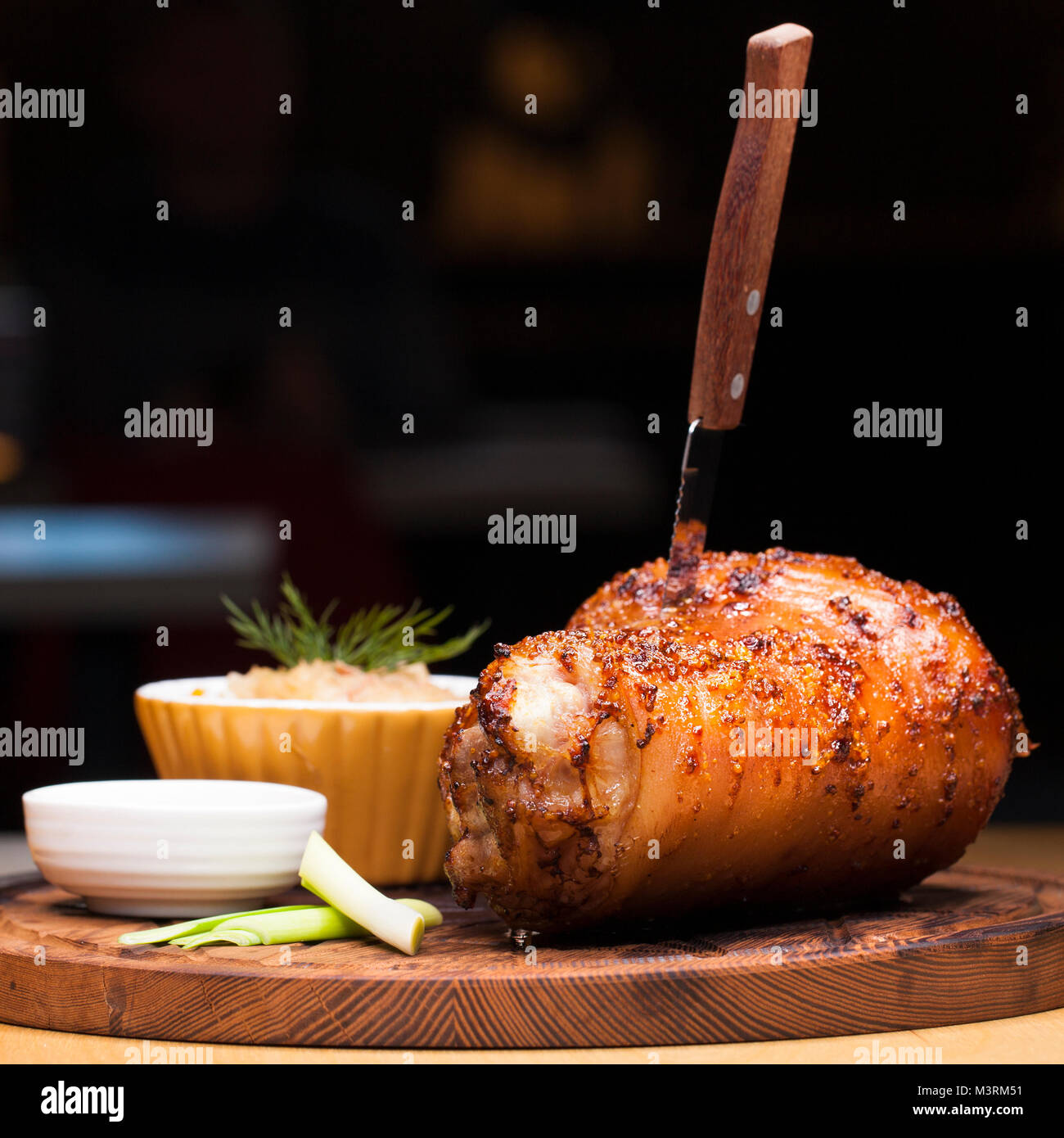 Restaurant dish - a large baked pork knuckle on a wooden tray Stock ...