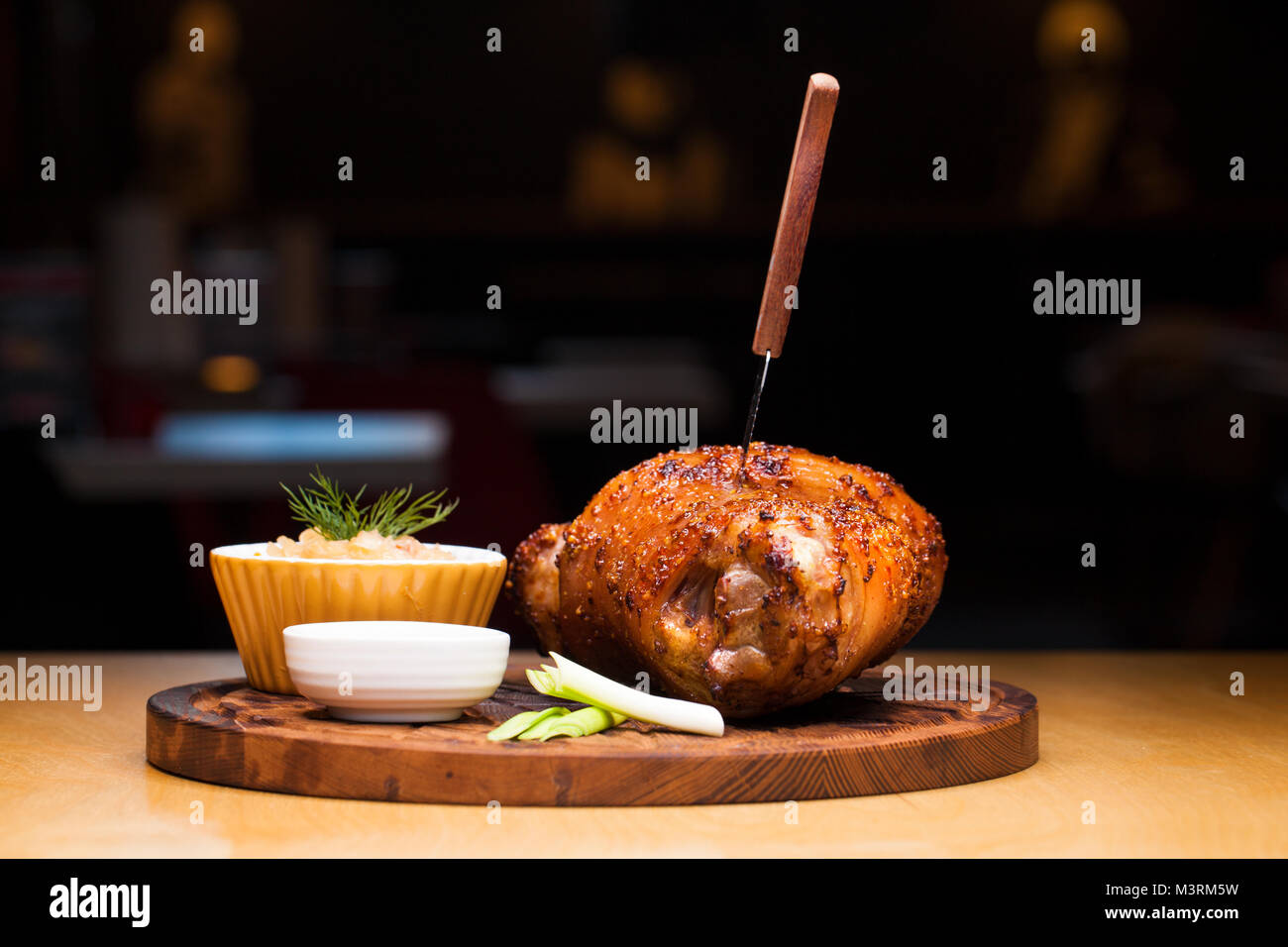 Restaurant dish - a large baked pork knuckle on a wooden tray Stock ...